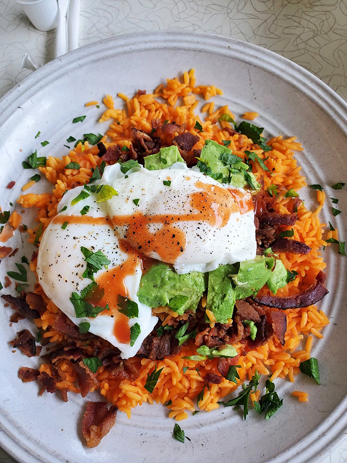A fiesta on a plate! Vibrant Mexican rice topped with perfectly poached eggs and avocado &ndash; breakfast with vacation vibes.