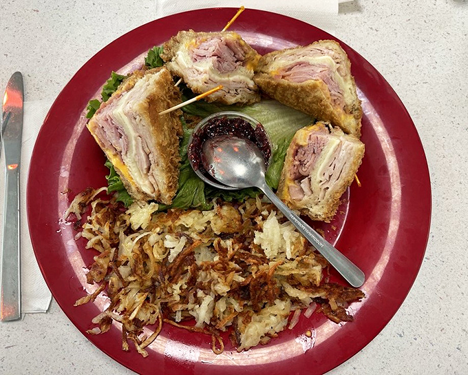 The Monte Cristo sandwich arrives golden and glorious, with hash browns that could convert potato skeptics instantly.