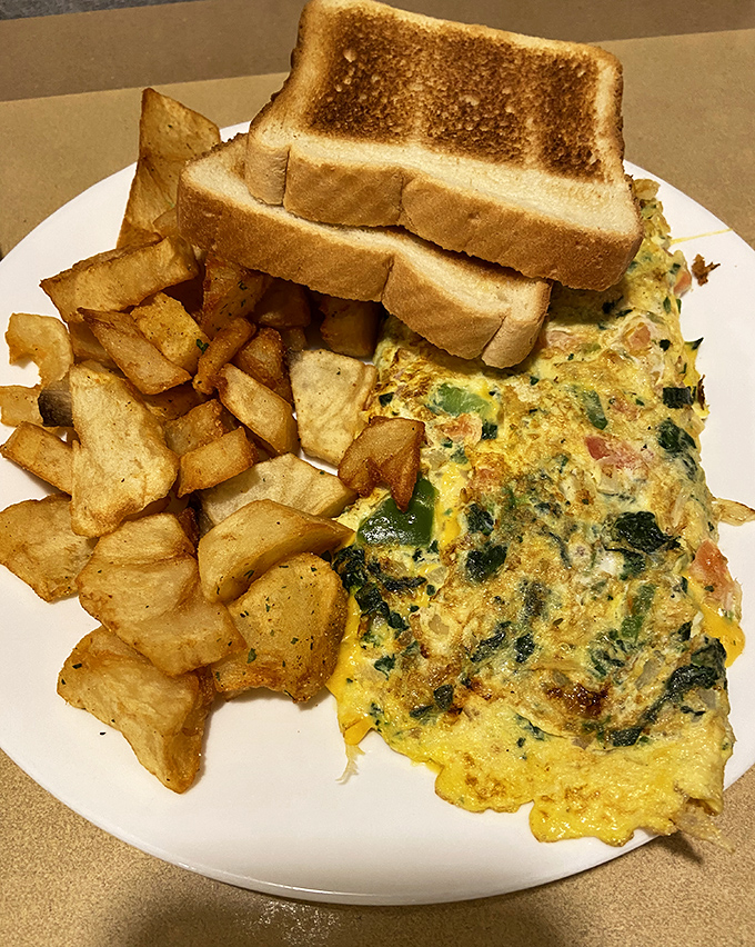 An omelet that's seen things&mdash;namely cheese, vegetables, and proper technique. Those home fries are the unsung heroes of the plate.