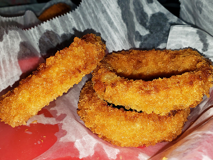 Golden-battered onion rings that shatter with each bite—these aren't afterthoughts but co-stars worthy of their own spotlight.