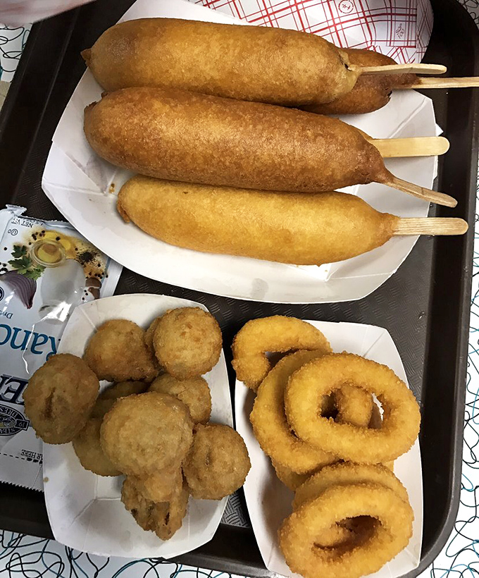 Three Cozy Dogs with onion rings and mushrooms &ndash; a tray that says "I'm on vacation and my diet starts when I cross state lines."