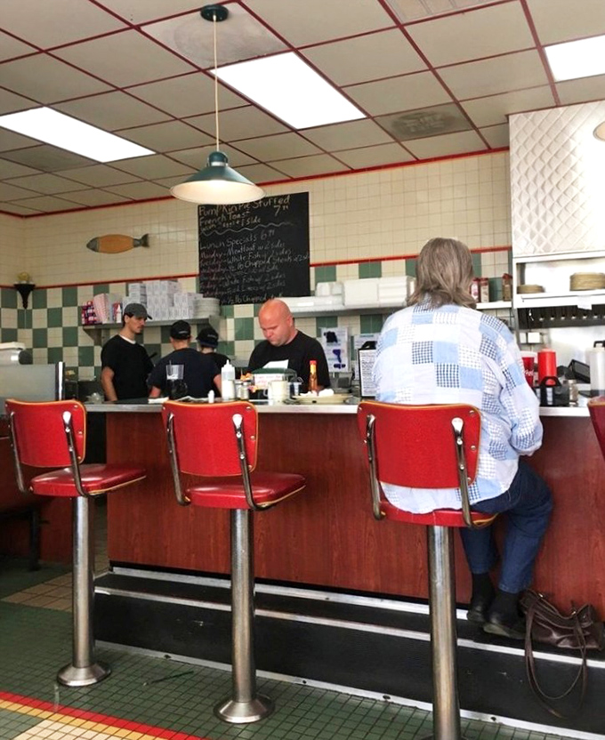 Red counter stools lined up like loyal soldiers, ready to support you through pancake stacks and life's big decisions.