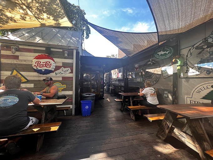The outdoor dining area offers the quintessential Key West experience: casual wooden benches, shade sails, and the promise of seafood bliss.