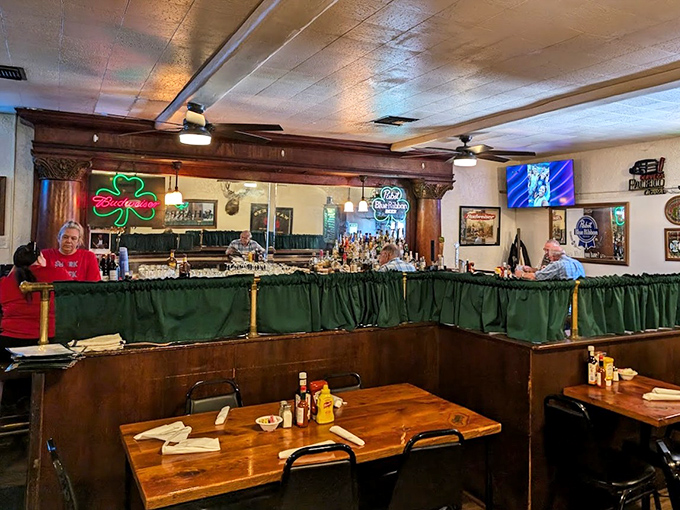 The bar area serves as Jamie's social hub, where neon signs cast a warm glow over wooden tables that have hosted countless celebrations and everyday meals alike.