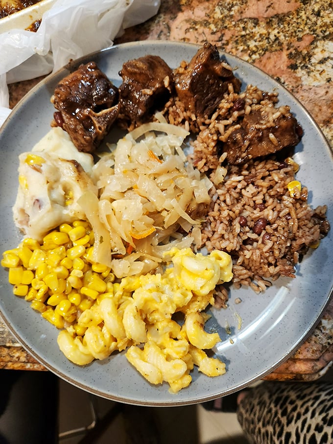 Oxtail so tender it falls apart at first glance, paired with traditional rice and peas perfection.