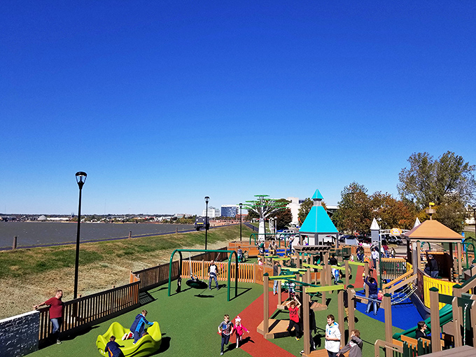 Riverside playground where kids burn energy with abandon while parents silently thank city planners for the Ohio River backdrop.