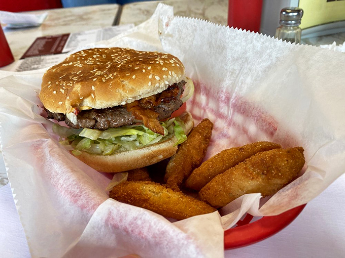 A burger that understands the assignment: juicy patty, melty cheese, fresh toppings, and those onion rings that deserve their own fan club.