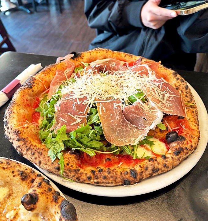 Prosciutto draped over a pizza like it's lounging on a Mediterranean beach. This pie doesn't just have toppings—it has attitude.