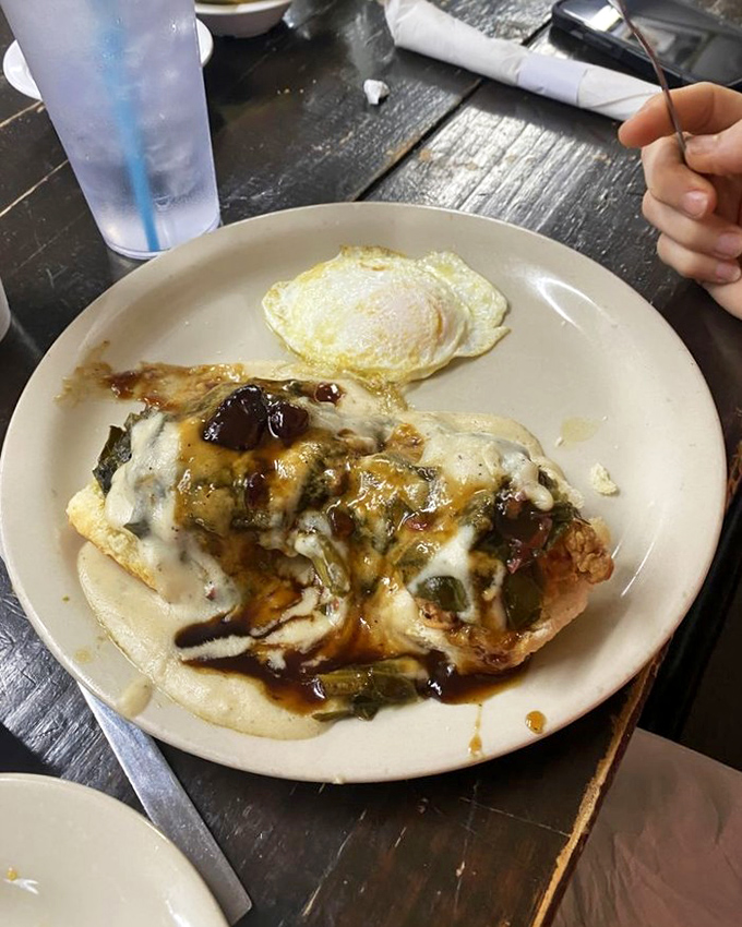 A plate that whispers "slow down" with every bite&mdash;tender meat under a blanket of gravy alongside a sunny-side egg.