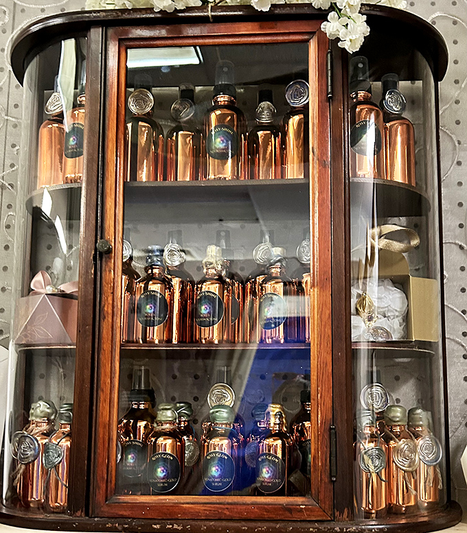 This vintage display cabinet showcases amber bottles like liquid gold behind glass&mdash;proof that even ordinary objects become treasures with the right presentation.