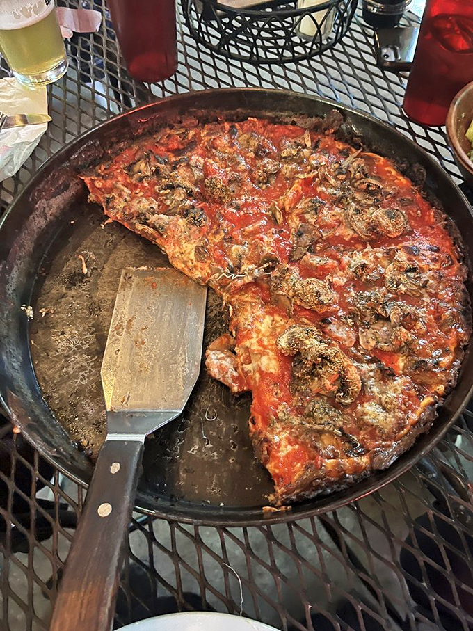 The pizza spatula tells the truth: this pan is half-empty because the pizza was too good to resist. Notice the perfect char on those mushrooms.