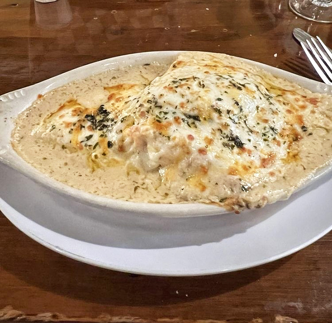 This seafood manicotti doesn't just sit on the plate&mdash;it lounges luxuriously in cream sauce like it's at a five-star spa for pasta.