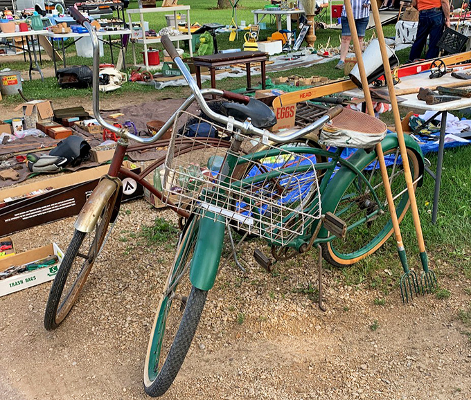 A vintage bicycle leans patiently against yard tools, like an old friend waiting to reminisce about neighborhood paper routes.