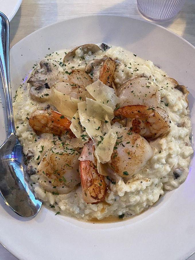 Shrimp and scallops lounging on a bed of creamy risotto like they're at a five-star resort. The parmesan shavings are just flexing.