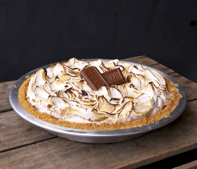 S'mores pie with toasted meringue peaks that would make a campfire jealous. No mosquitoes, no singed eyebrows, just pure nostalgic bliss.