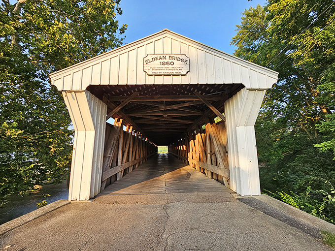 Summer's greenery frames the entrance perfectly, creating that "gateway to somewhere special" feeling that makes covered bridges so appealing.