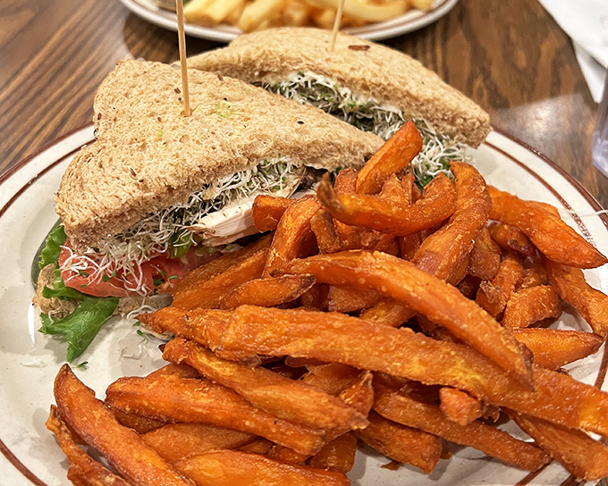 A sandwich that understands the importance of balance: hearty fillings, wholesome bread, and sweet potato fries that deserve their own spotlight.
