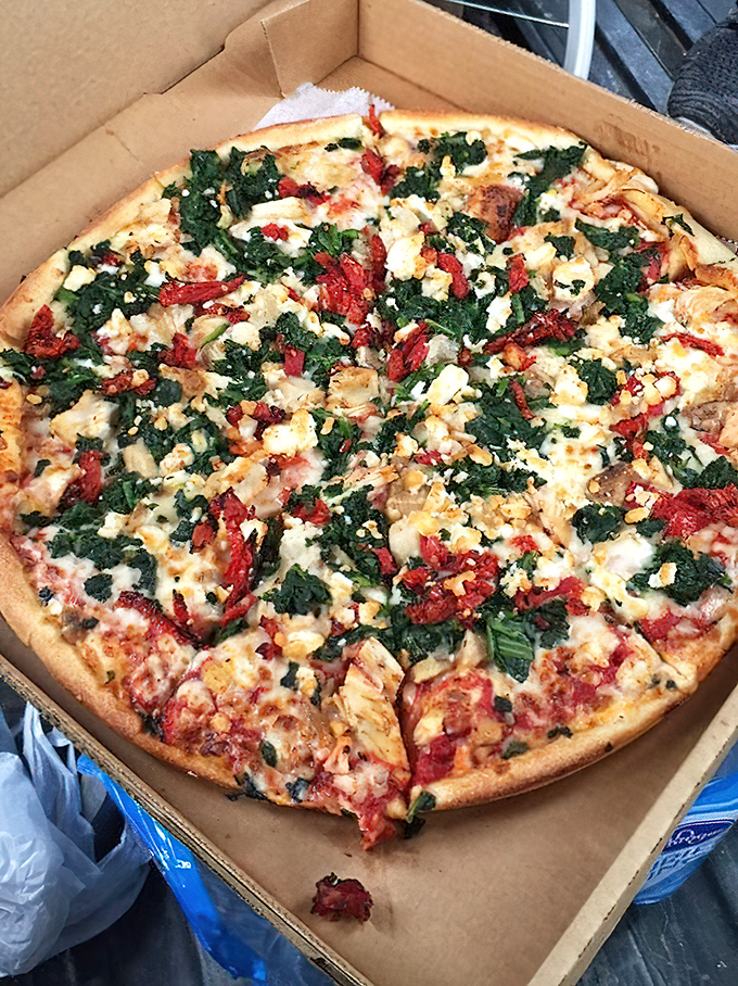 A pizza masterpiece featuring chicken, spinach, and sun-dried tomatoes. When vegetables look this good on pizza, even your doctor would approve.