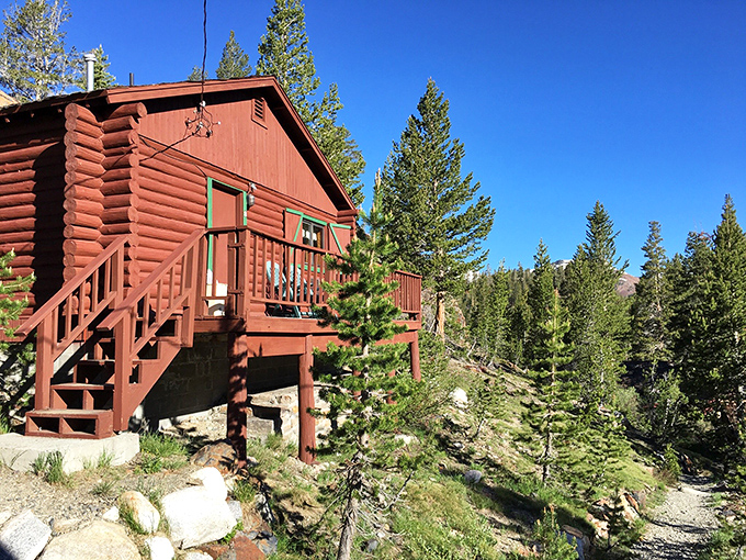 This rustic red cabin perched among pines is what city folks imagine when they say, "I'm running away to the mountains."