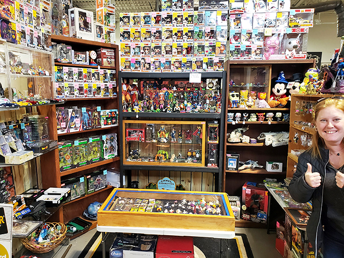 Funko Pop figures stand at attention alongside vintage toys. The collector's gleeful thumbs-up says it all&mdash;another successful treasure hunt completed!