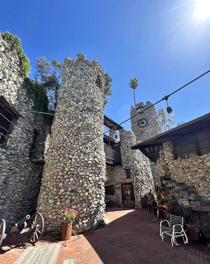 Twin stone towers create a medieval courtyard that feels impossibly out of place yet perfectly at home in California. Architecture as rebellion.
