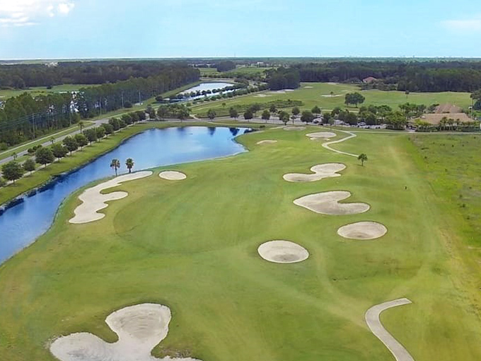 The golf course stretches toward the horizon, its sand traps gleaming like Mediterranean beaches without the hassle of sunscreen application.
