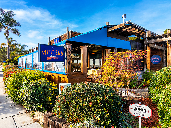 West End Bar & Kitchen wraps coastal cuisine in a package of wood, blue awnings, and lush landscaping that screams "vacation mode activated."