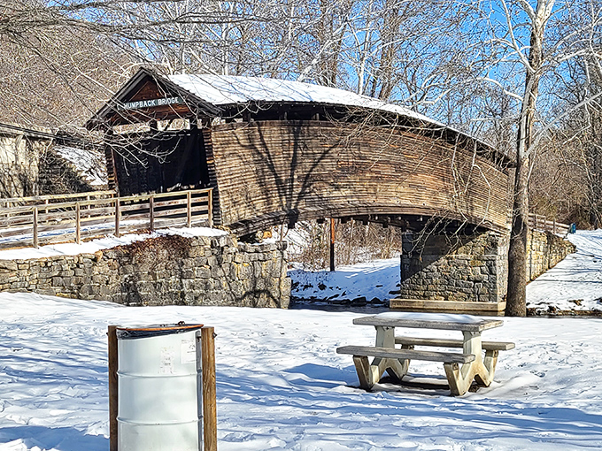 Winter whites frame weathered woods in perfect harmony. Snow transforms the historic span into something straight out of a vintage holiday card.