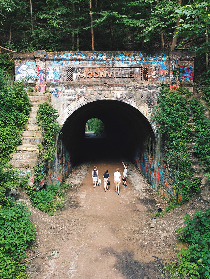 From above, the tunnel entrance nestles into the hillside, surrounded by lush greenery that hides its eerie reputation.