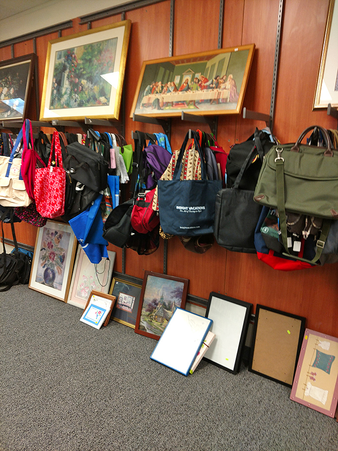 Religious art hangs above a colorful array of bags&mdash;the juxtaposition creating an unintentional gallery where the sacred and practical coexist in thrift store harmony.