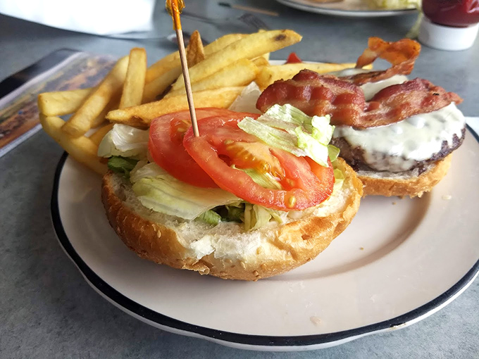 A burger that requires both hands and a strategy. Golden fries standing at attention, ready to be deployed against hunger.