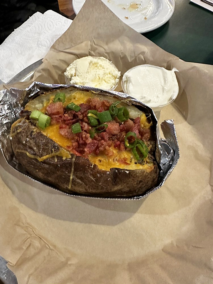 Not just a baked potato – it's a canvas for barbecue artistry, where cheese, bacon and green onions perform a flavor symphony.