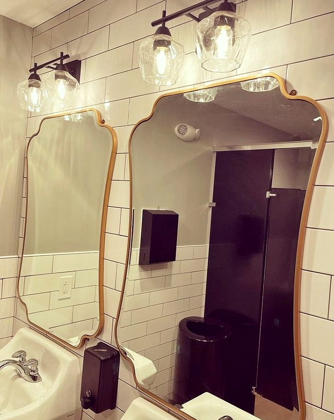 Even the restroom continues the design story, with elegant mirrors and subway tiles that would make any home renovation show proud.