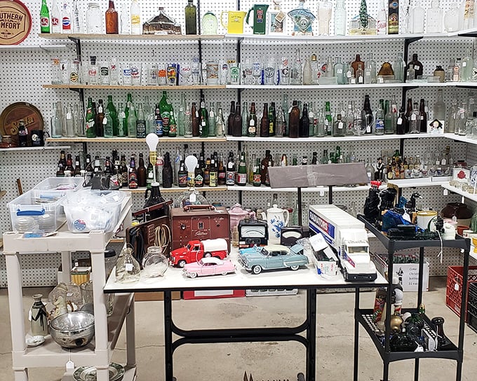 A bottle collector's dream wall&mdash;where vintage Coca-Cola meets forgotten local brews, with toy cars parked below like a miniature drive-in.