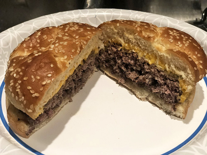 The sesame-studded crown atop this burger jewel adds both texture and visual appeal. Notice how the cheese drapes perfectly over the edges.