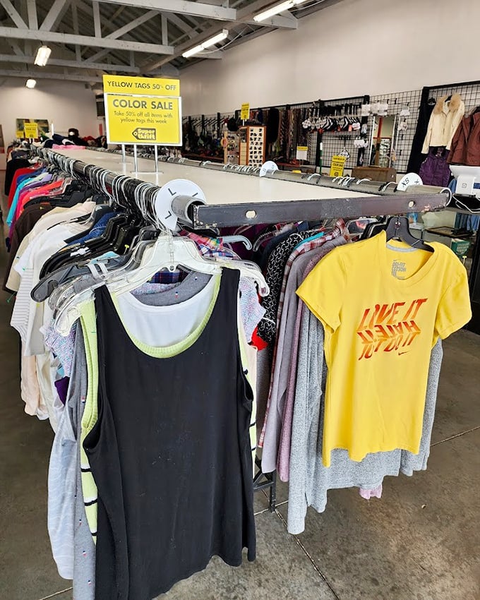 Color-coded clothing racks create a rainbow road of fashion possibilities. That "Live It Up" t-shirt is practically a thrift store philosophy statement.