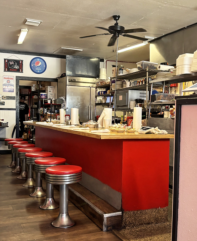 The counter where breakfast dreams come true. Those classic red stools have witnessed countless coffee refills and life-changing food decisions.