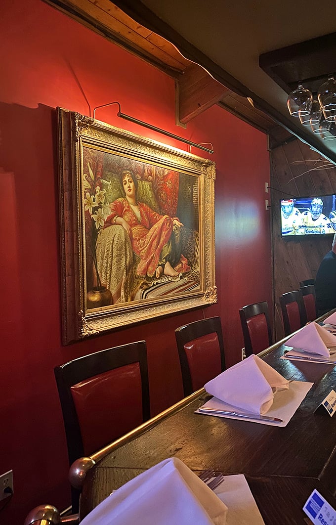 Red walls, ornate artwork, and elegant place settings – like dining in a Renaissance painting where the main subject is your imminent food happiness.