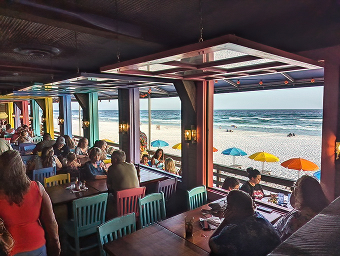 Dining with a view that makes you question every life decision that doesn't involve living at the beach. The colorful chairs are as vibrant as the conversations. 