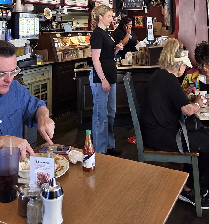 The dining room hums with the universal language of good eating. Notice the hot sauce bottle&mdash;a necessary accessory for serious chicken enthusiasts.