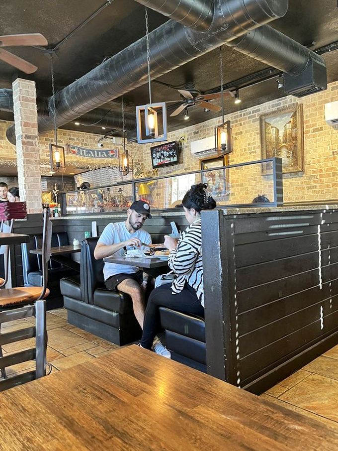 Cozy booths where pizza dreams come true. The industrial ceiling above only makes the warmth below feel that much more inviting.