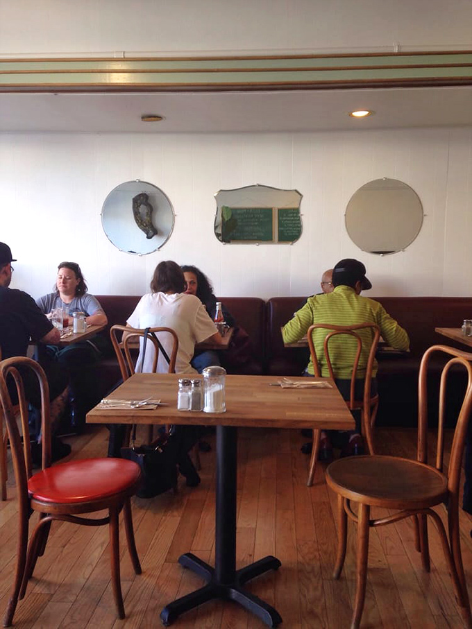 Where strangers become temporary neighbors sharing the universal religion of good food, separated only by bentwood chairs and mirrored by vintage glass.