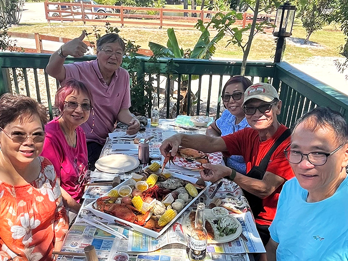 Outdoor dining with friends and newspaper-covered tables. The universal language of "pass the crab crackers" brings people together.