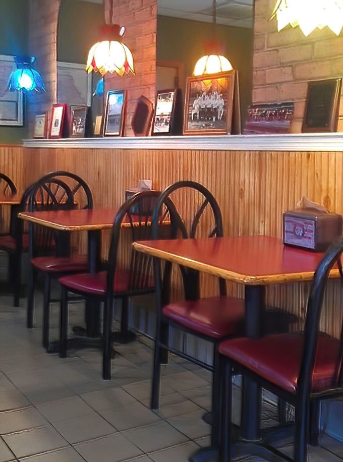 Red vinyl seats and wood paneling create that classic pizzeria vibe where memories are made, one slice at a time. Norman Rockwell would approve.