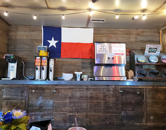 The drink station&mdash;where sweet tea flows like liquid gold&mdash;stands ready beneath rustic wood walls and the ever-present Texas colors.