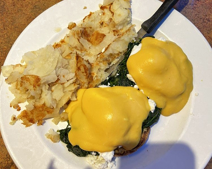 Eggs Benedict with spinach&mdash;where hollandaise sauce flows like liquid sunshine over perfectly poached eggs. Breakfast architecture at its finest. 