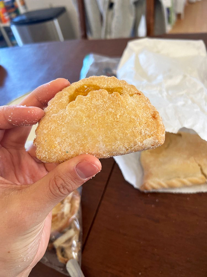 Golden-edged and sugar-dusted, this empanada holds its sweet secret inside, like a delicious mystery waiting to be solved with each bite.