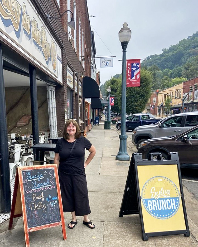 The sidewalk scene captures Sylva's small-town charm, with mountains rising in the background and friendly faces ready to welcome hungry visitors.