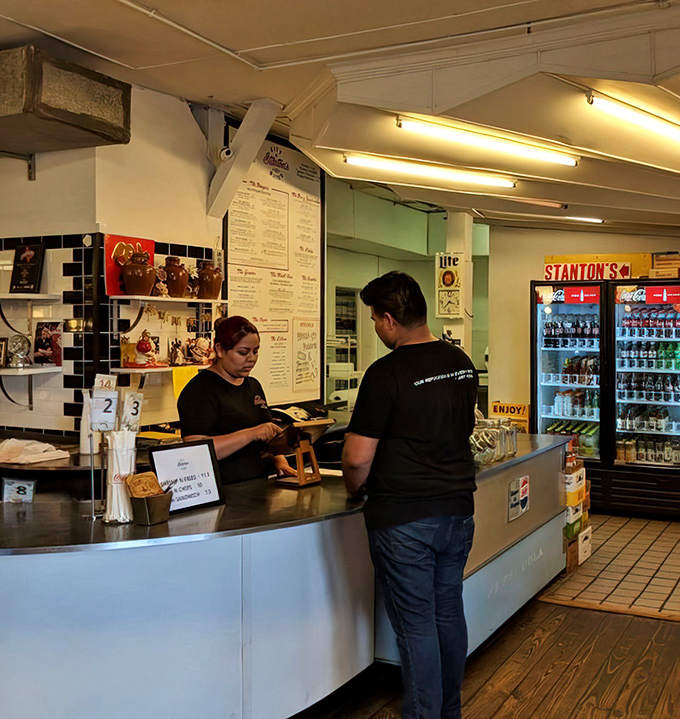The counter where burger dreams become reality. Like watching artists at work, except the canvas is edible and the paint is delicious.