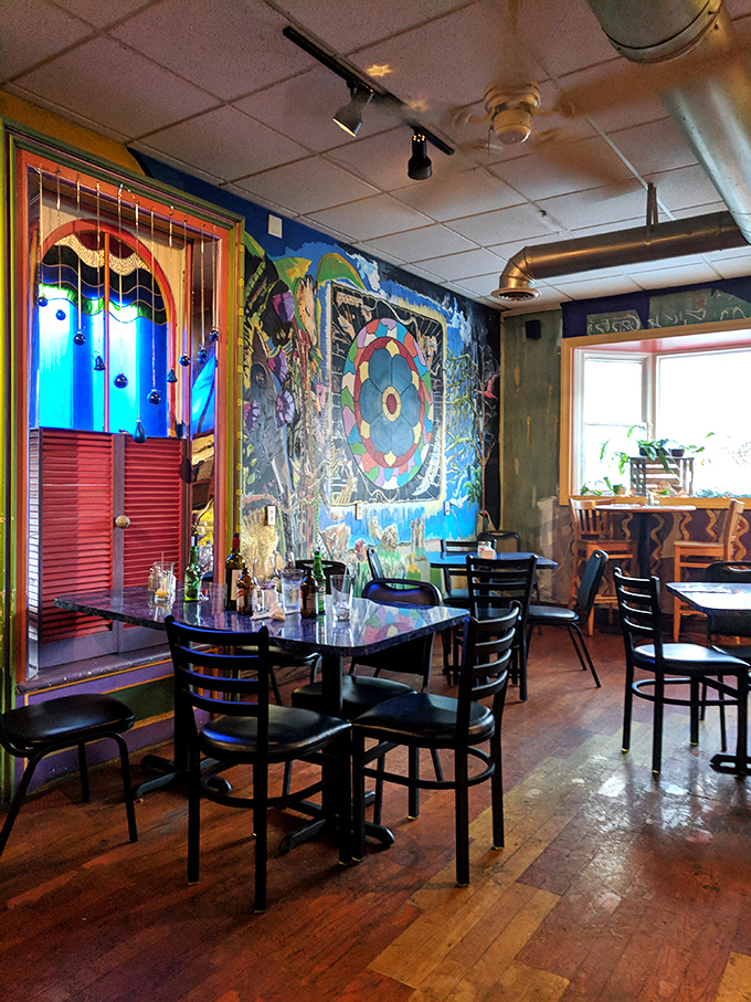 Vibrant murals transform what could be an ordinary dining room into an immersive art experience. Even empty tables seem to hum with creative energy.